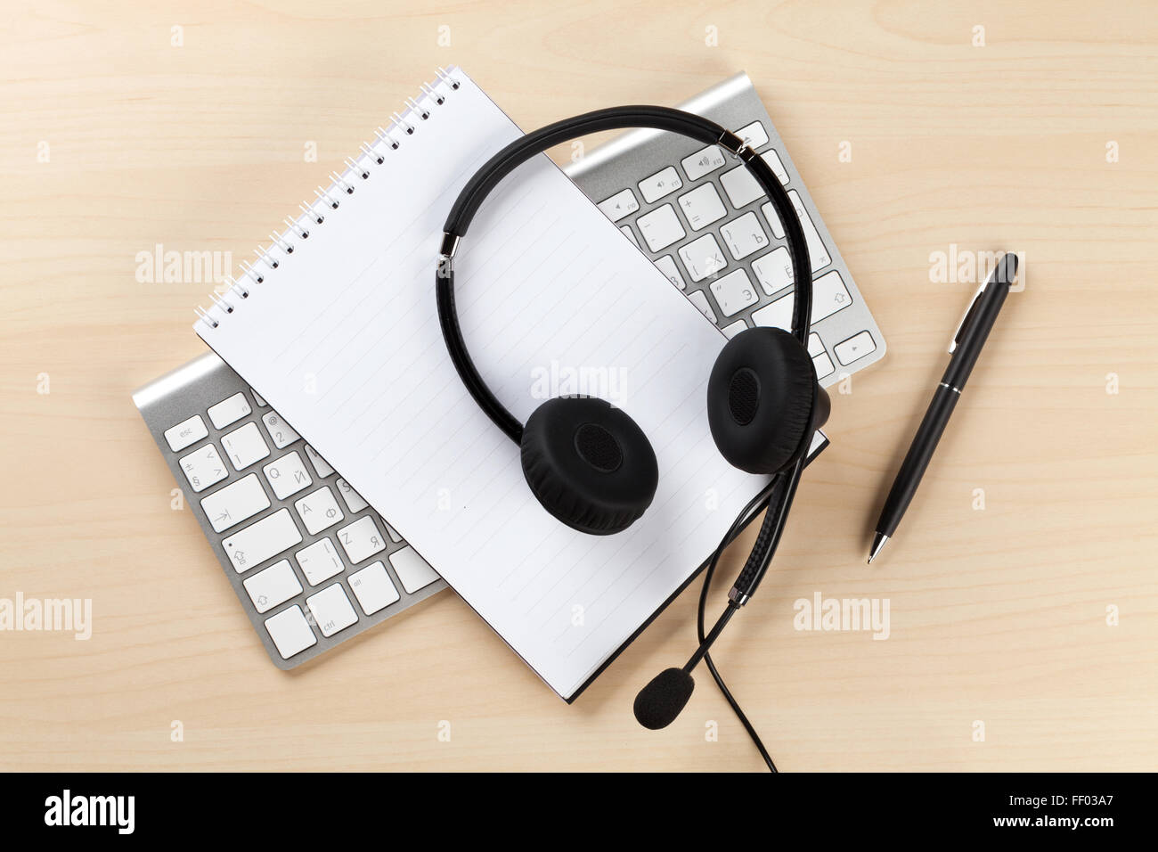 Office desk with headset laying on keyboard. Call center table. Top ...