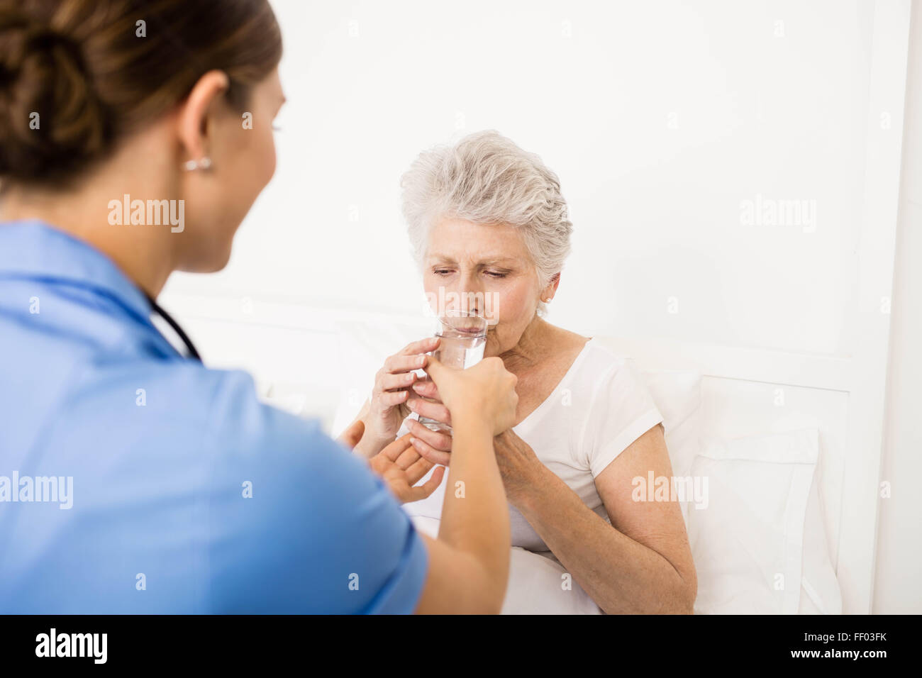 Nurse taking care of suffering senior patient Stock Photo - Alamy