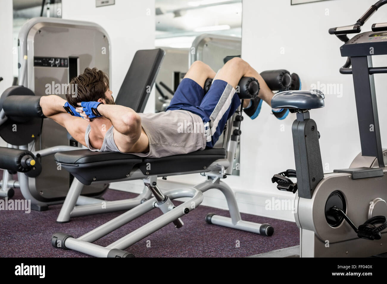 Man doing abdominal crunches on bench Stock Photo - Alamy