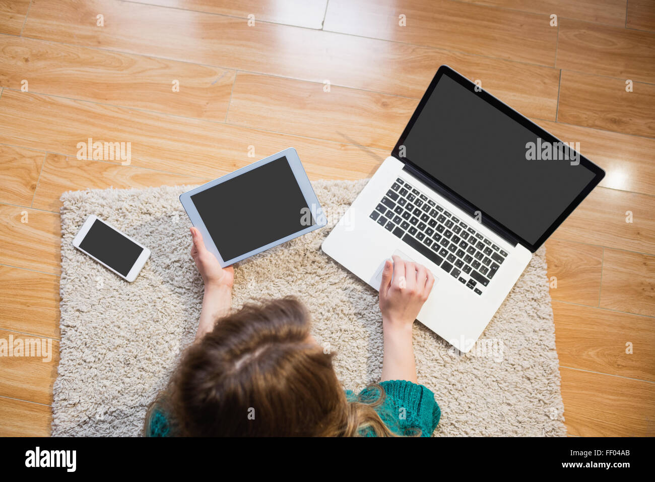 Woman lying on the floor while using her laptop and tablet Stock Photo ...