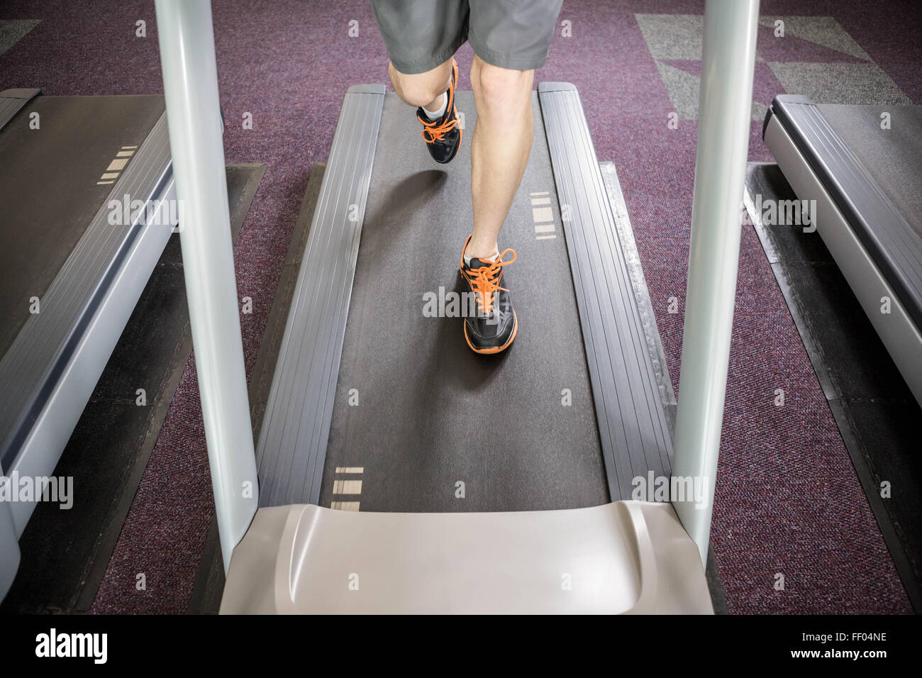 Lower section of man running on treadmill Stock Photo - Alamy