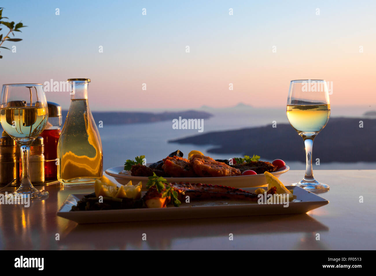 Romantic dinner for two at sunset.Greece, Santorini, restaurant on the ...