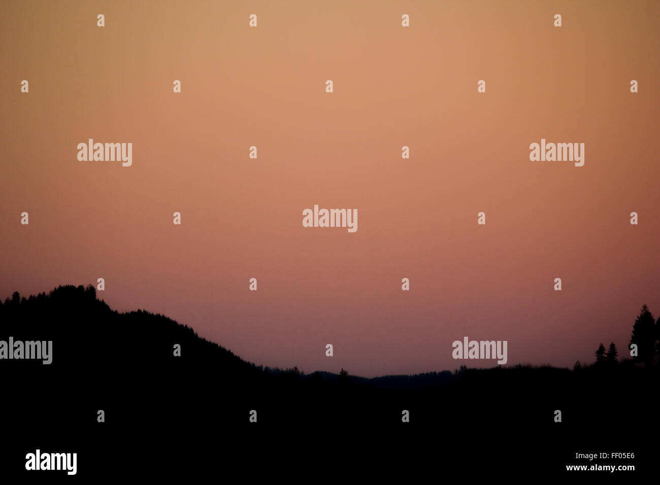 A clear sky at sunset with muted pink, orange and brown colors and ...