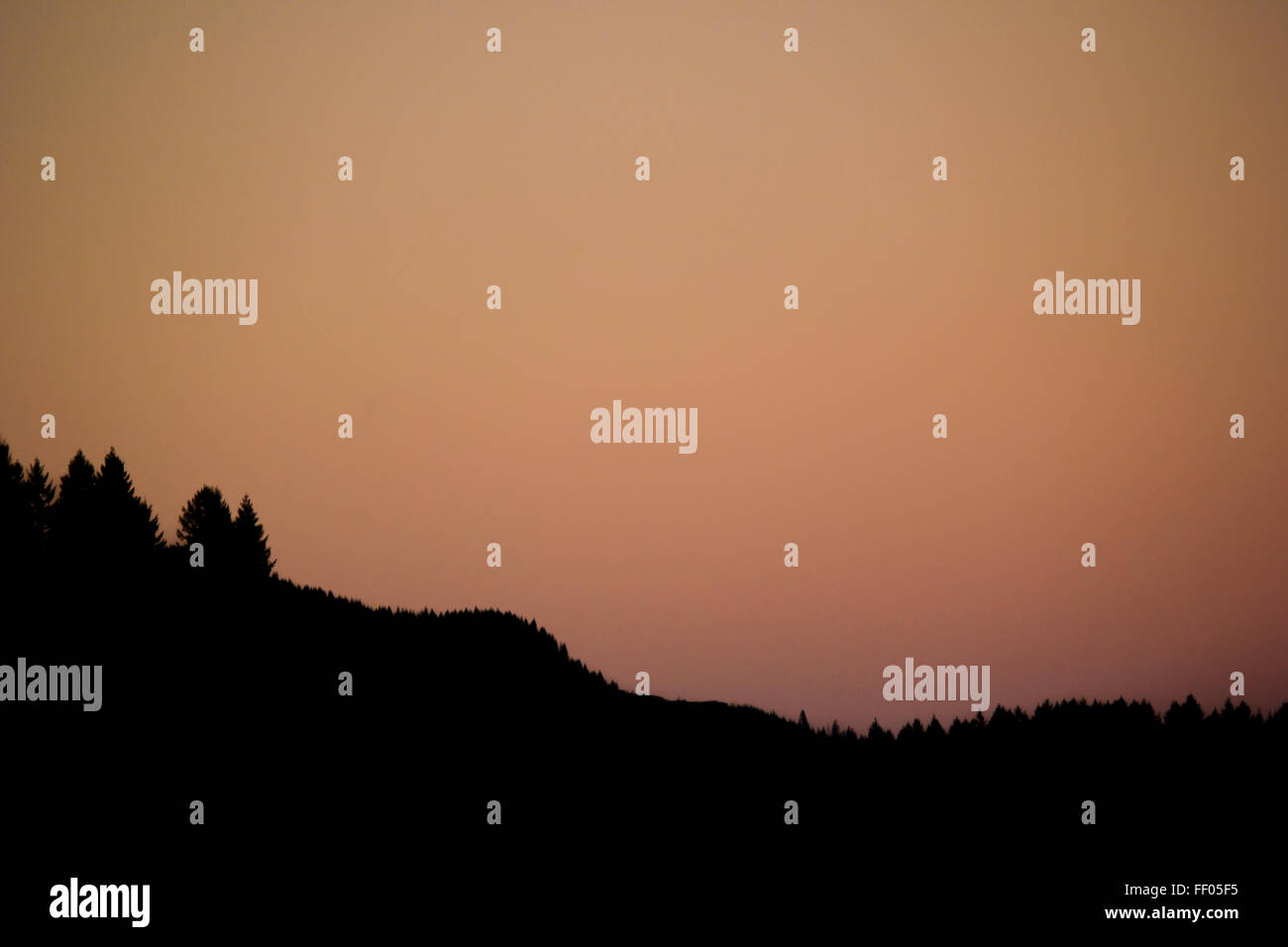 A clear sky at sunset with muted pink, orange and brown colors and ...