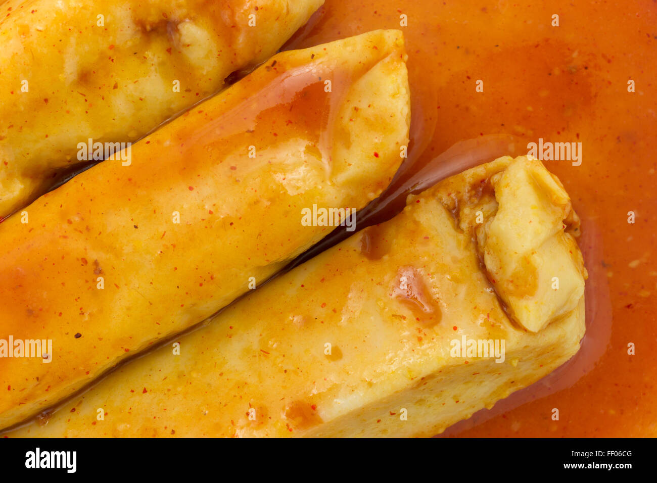 A very close view of canned tamales in chili sauce on a plate Stock ...
