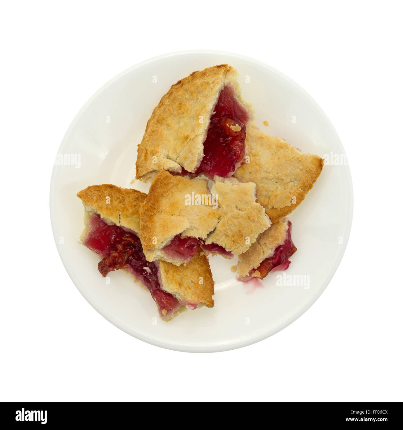 Top view of a small cherry pie in pieces on a plate isolated on a white ...