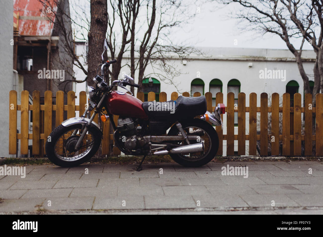 A maroon Honda motorcycle, parked and captured in detail. The sleek ...