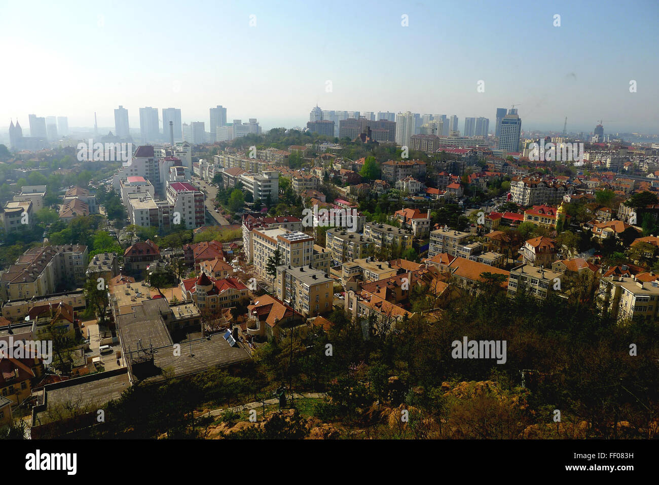 A cityscape showing a blend of a small town and towering skyscrapers ...