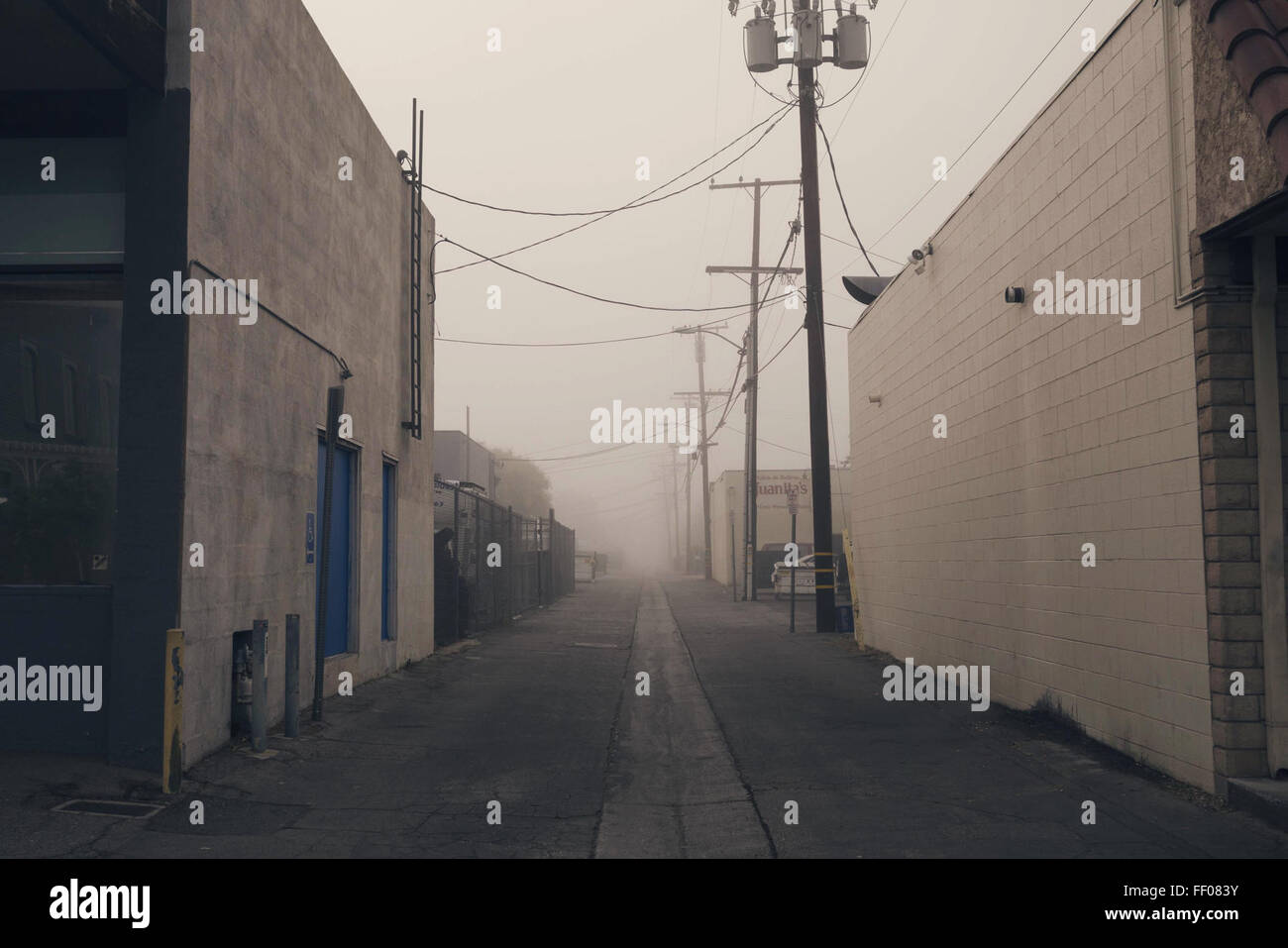 A back alley shrouded in smog, giving the scene a dark and mysterious ...