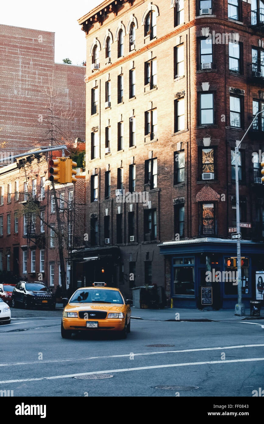 A yellow taxi cab parked on a bustling urban street corner. The scene ...