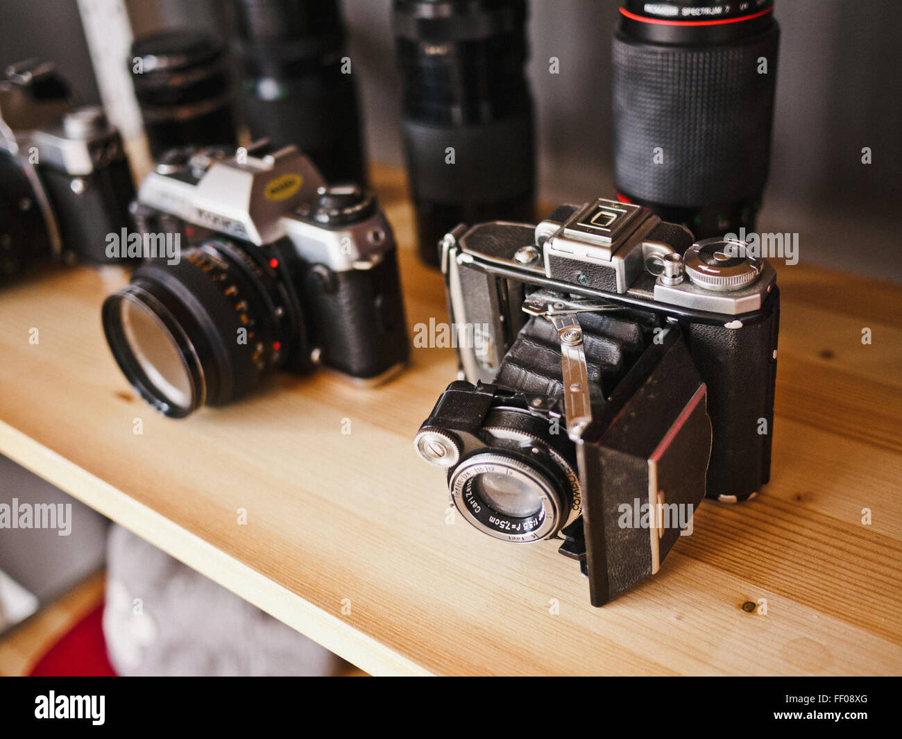 A collection of vintage cameras displayed on a shelf, showcasing the ...