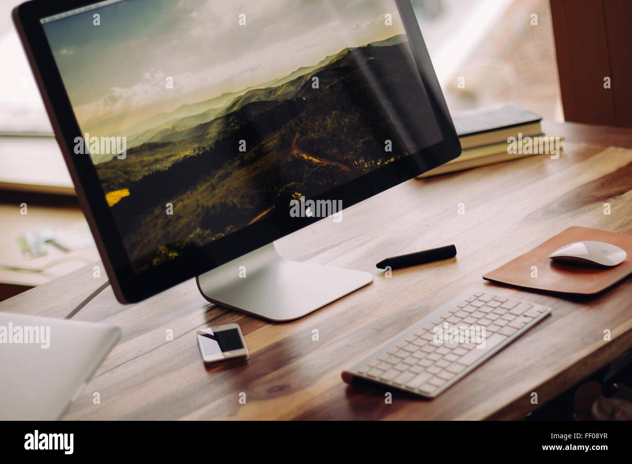 An iMac computer set up on a desk, featuring a sleek Apple design. The ...