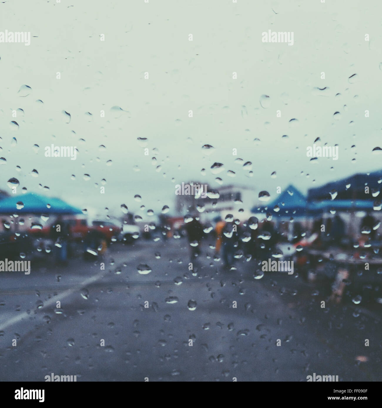 Water droplets accumulate on a window, their translucent forms creating ...