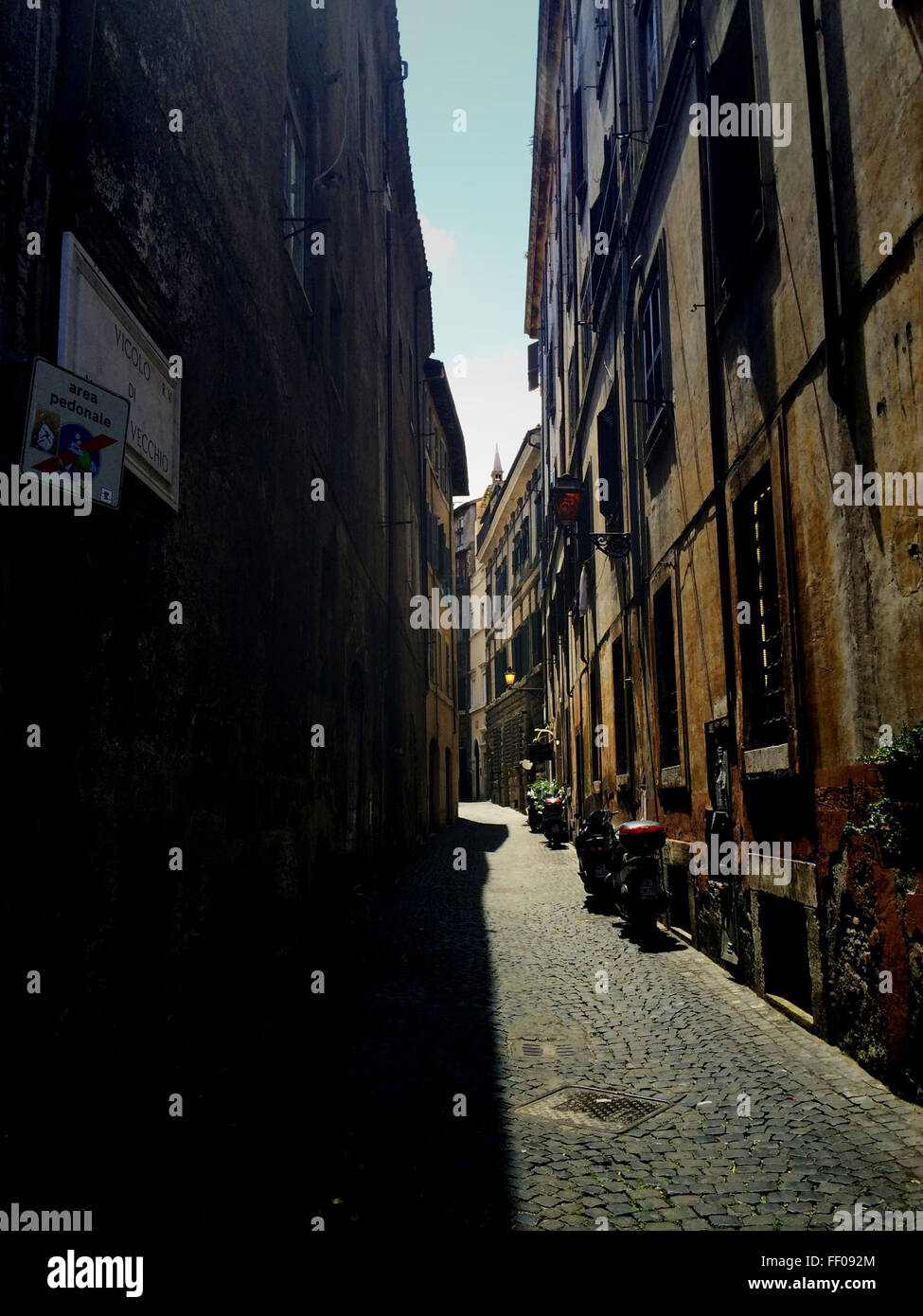 A narrow city alley, with old architecture, tall buildings, and a ...