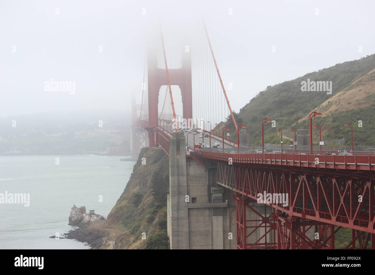 The Golden Gate Bridge is partially obscured by fog, creating a ...
