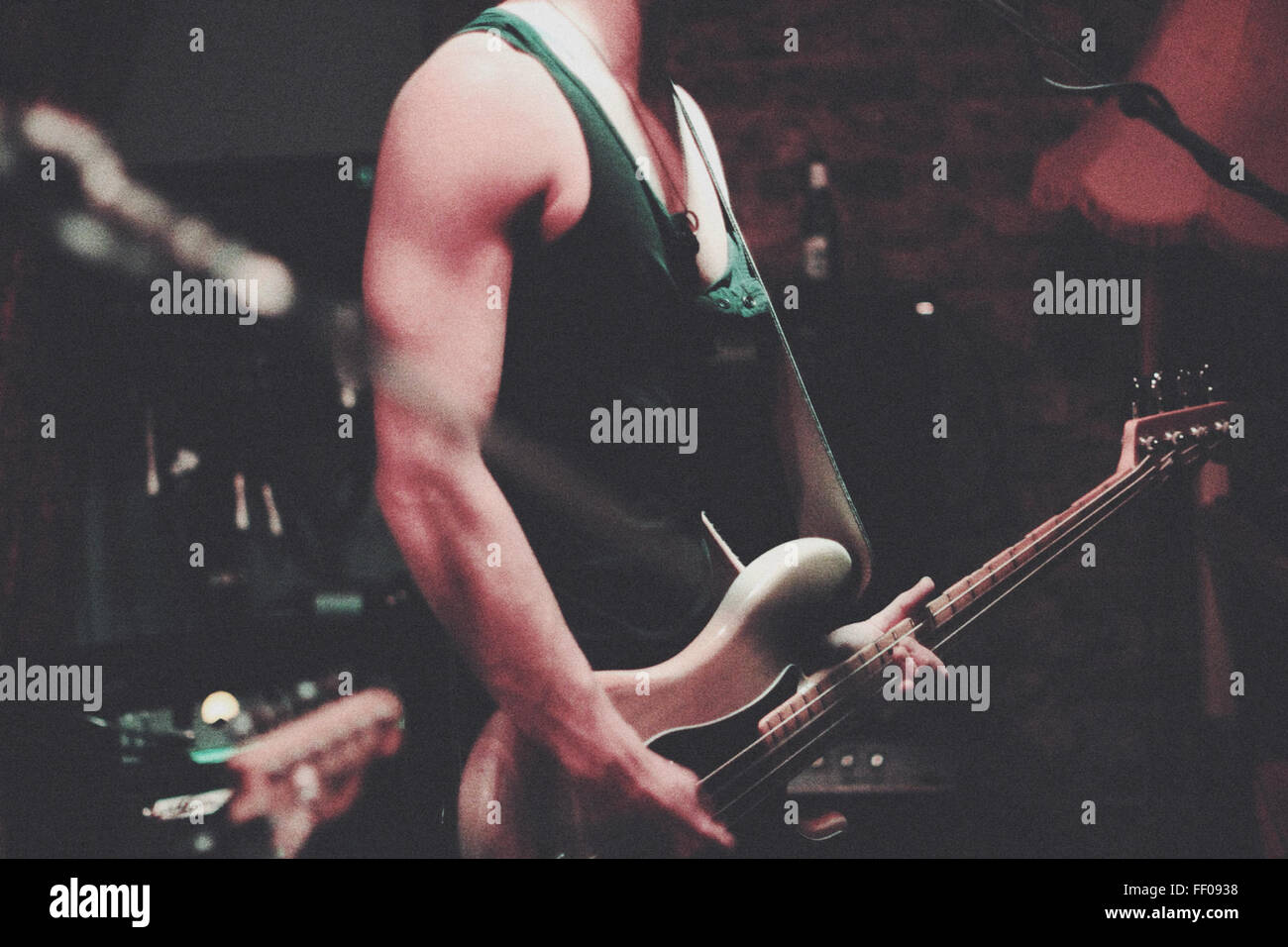 A bass player performs on stage at a concert, playing an electric bass ...
