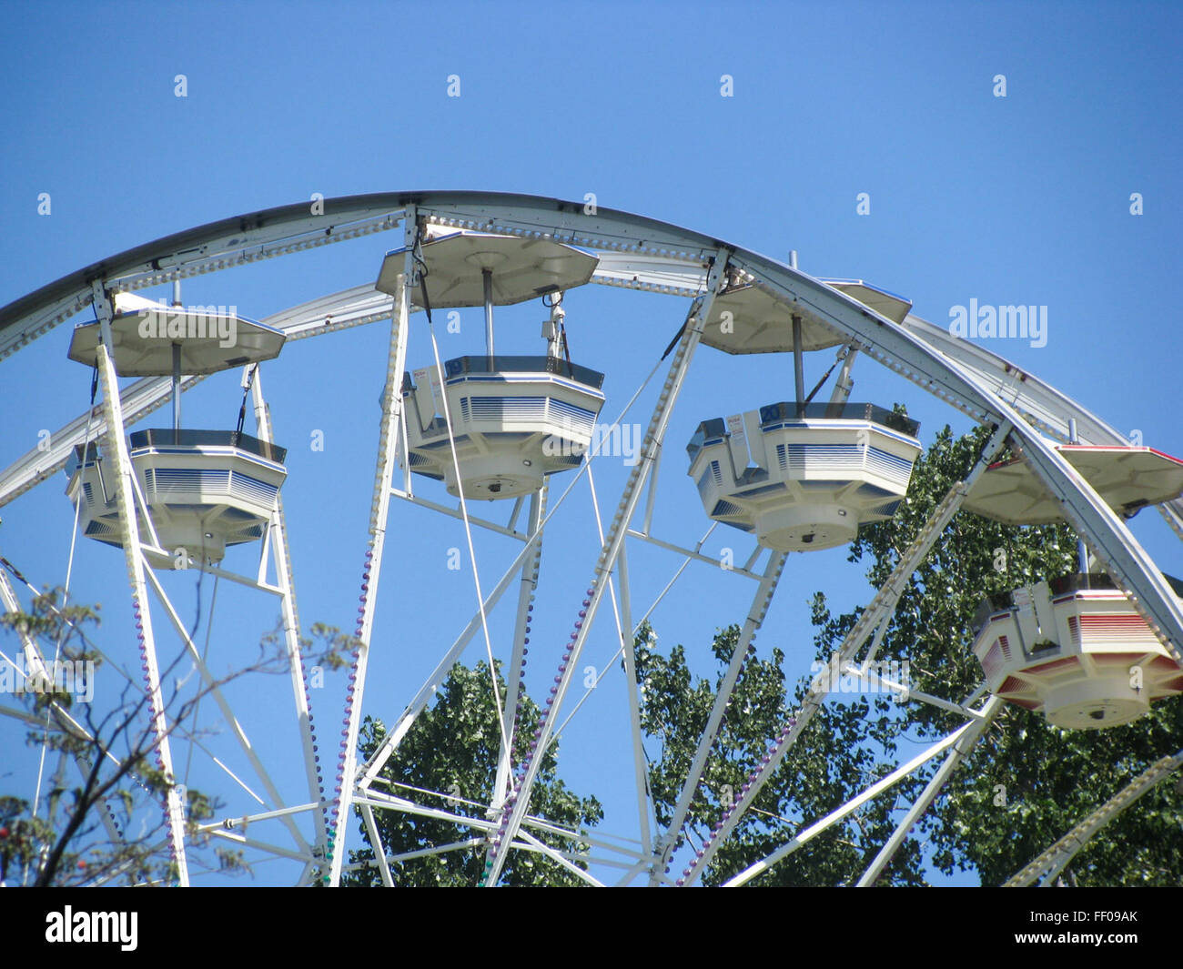 A Ferris wheel against a clear blue sky, featuring its iconic rotating ...