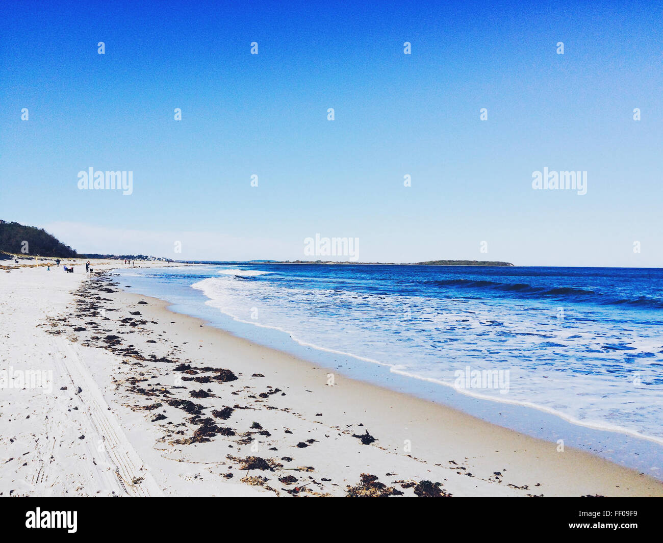 A peaceful beach with clear blue ocean water, stretching out to the ...