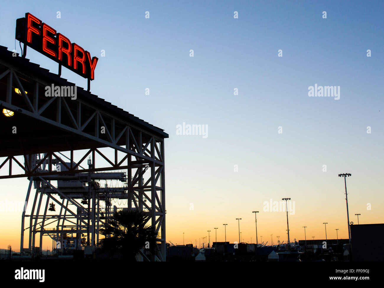 A red neon sign displaying 'Ferry' illuminates the dock area as the sun ...