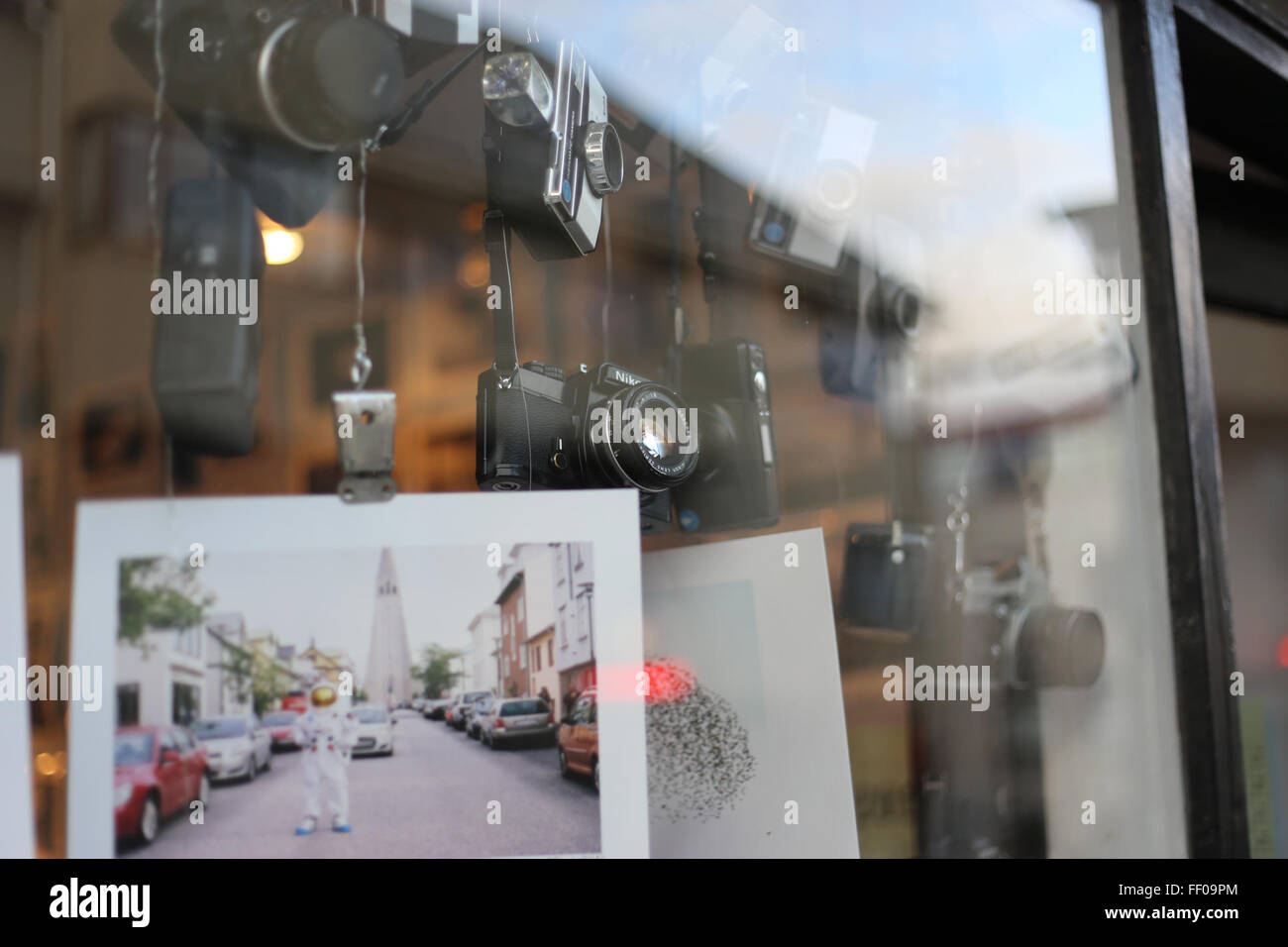 A shop window displaying various photographs. The reflections in the ...