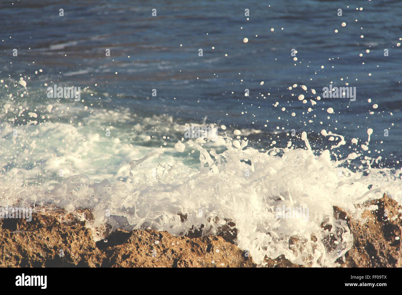 Ocean waves crash against rocks, creating splashes as water hits the ...