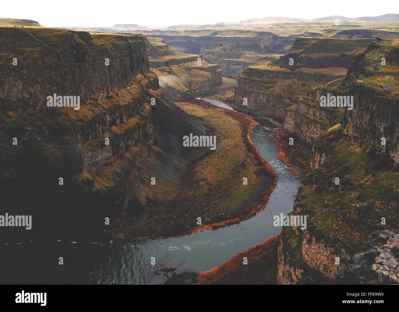 A river flows through a valley, with surrounding earth and geological ...