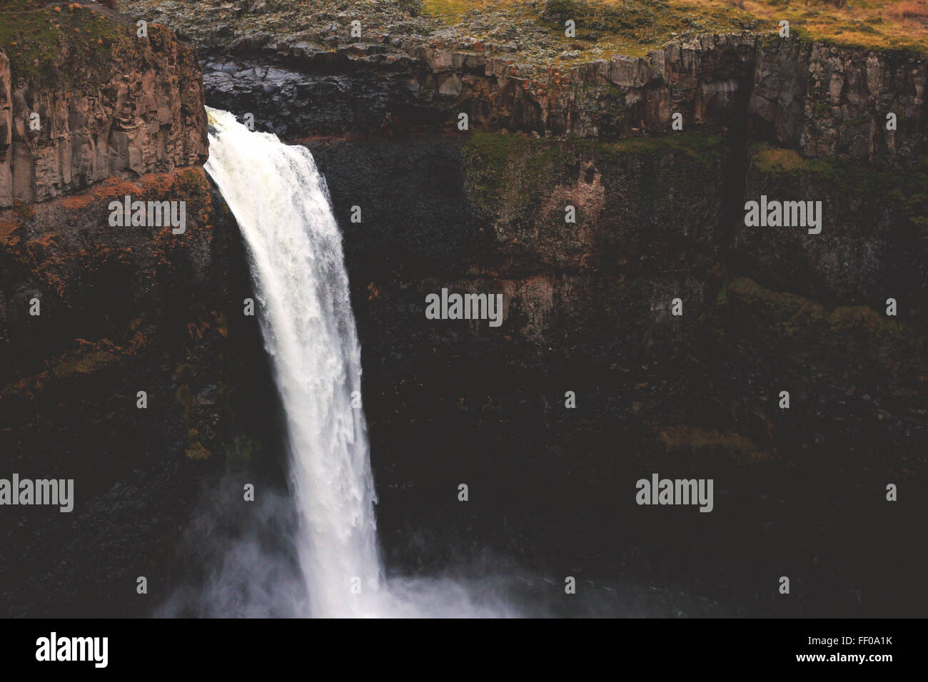 A waterfall cascading down a cliff, surrounded by natural beauty. The ...