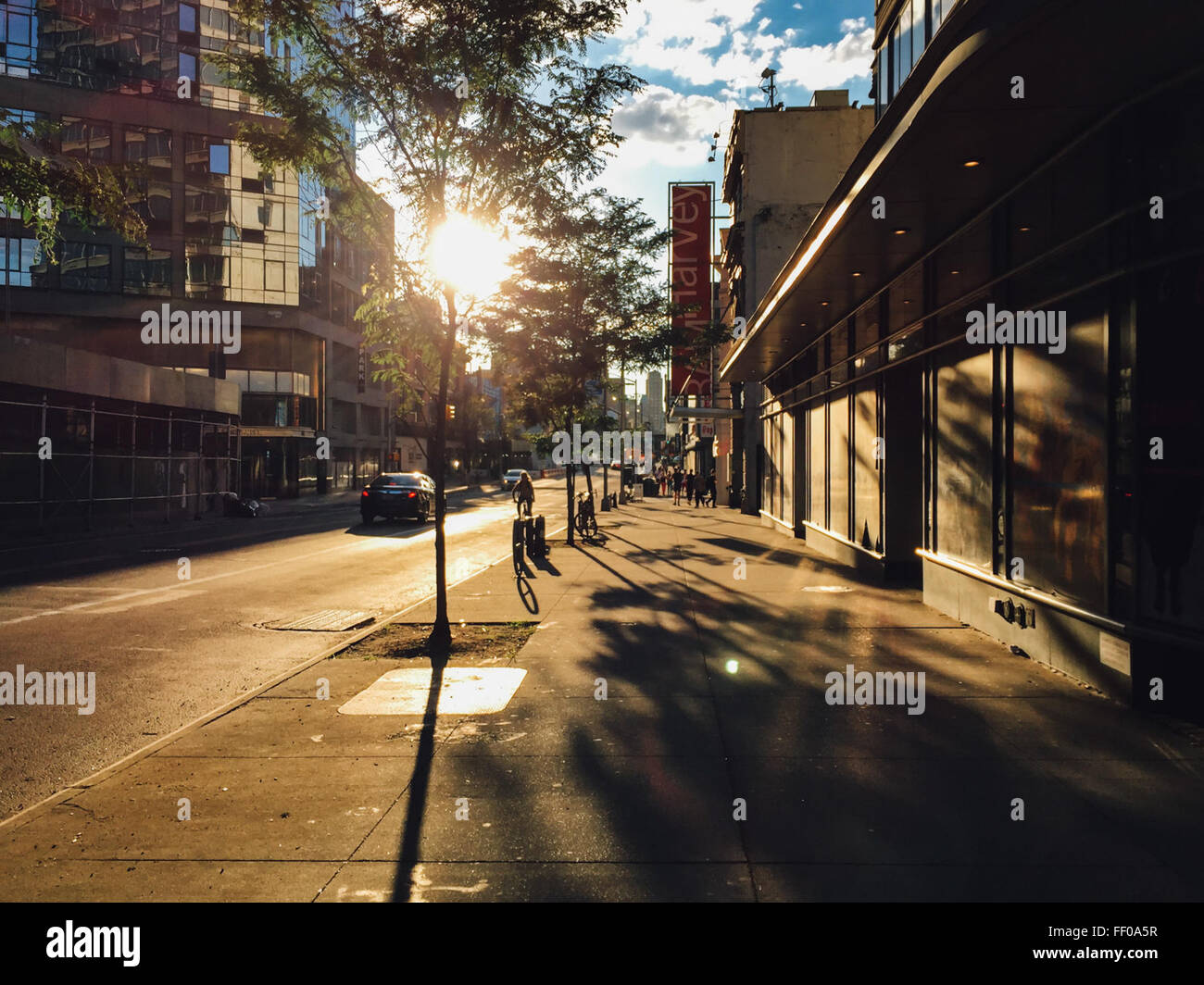 A vibrant urban scene with a cyclist riding along a sidewalk beside ...