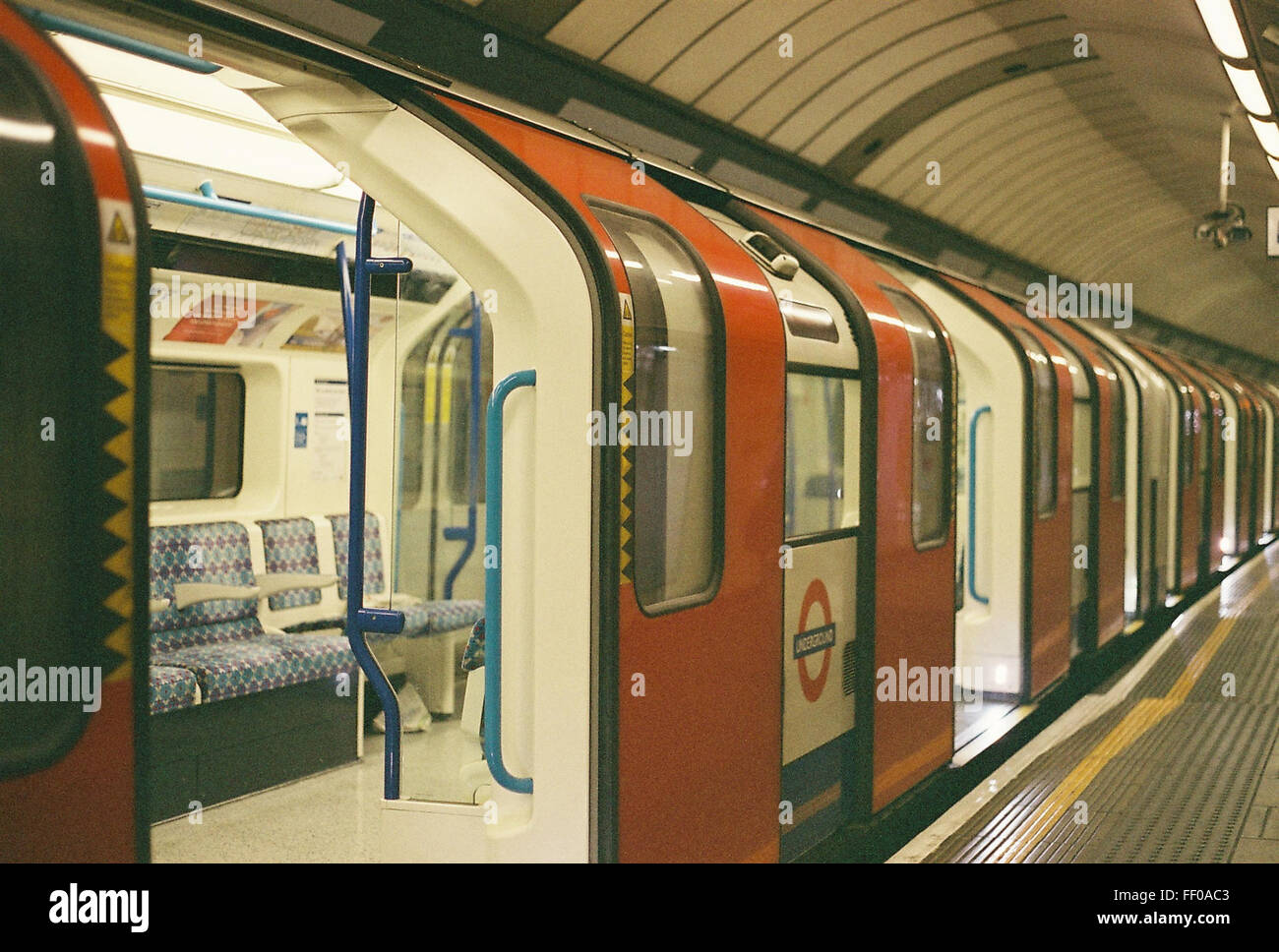 A busy London Underground station with commuters waiting for trains ...