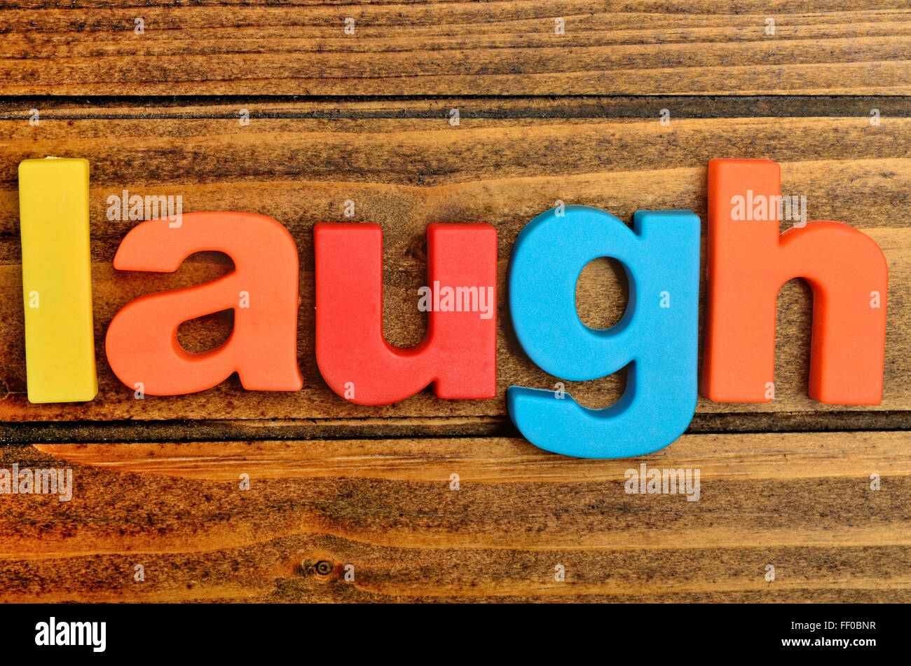 Laugh word on wooden table Stock Photo - Alamy
