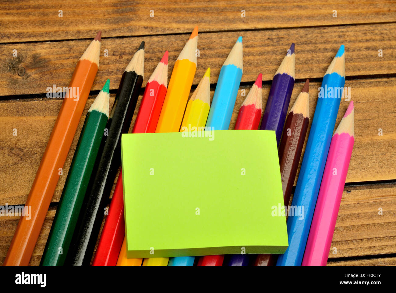 Empty notes with colorful pencils on wooden table Stock Photo - Alamy