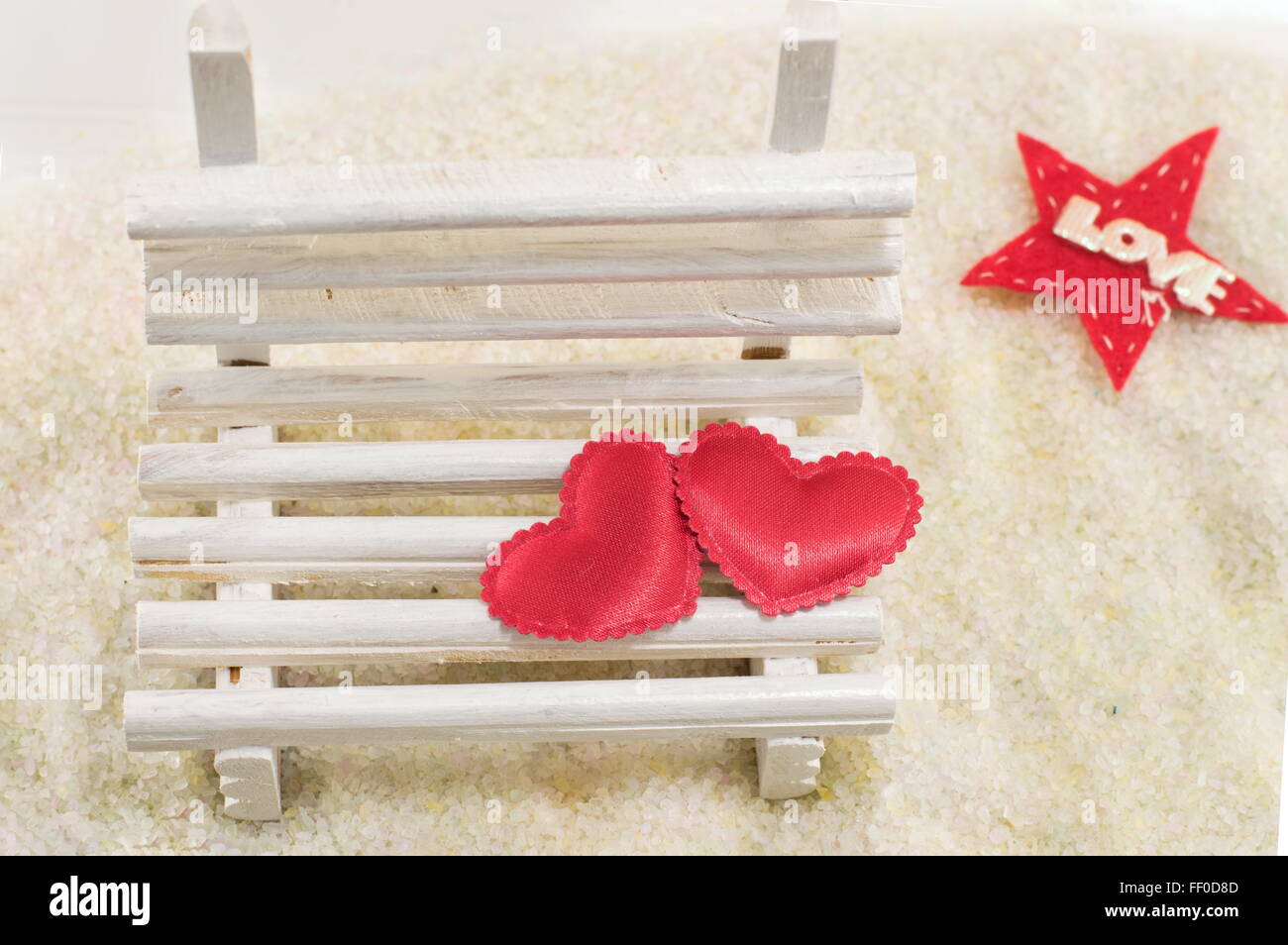 Two hearts on a miniature wooden bench with a love note Stock Photo - Alamy