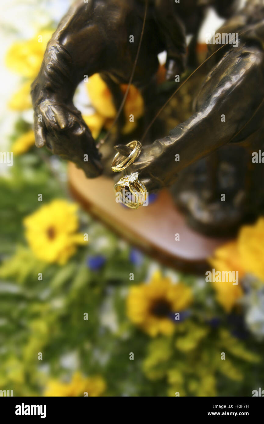 Bride and groom's wedding rings on a sculpture of horse figurines at a ...