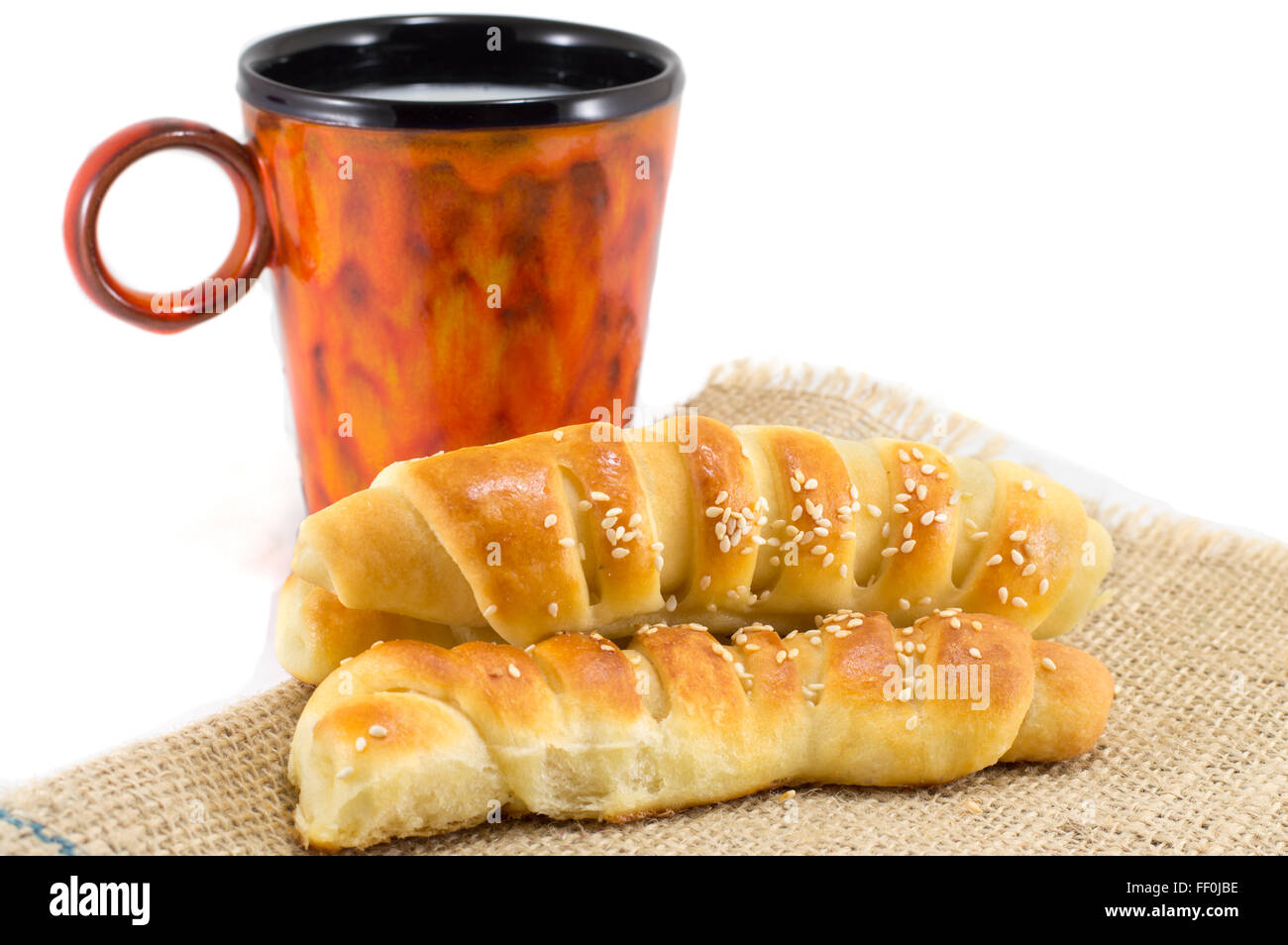 bunch of sesame pastry with a mug of milk Stock Photo - Alamy