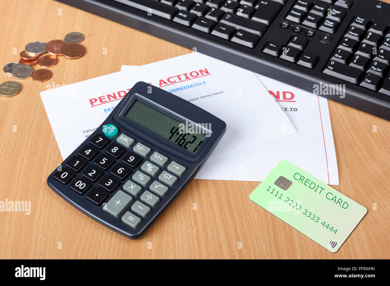 Desk showing final demands with credit card and a calculator along side ...