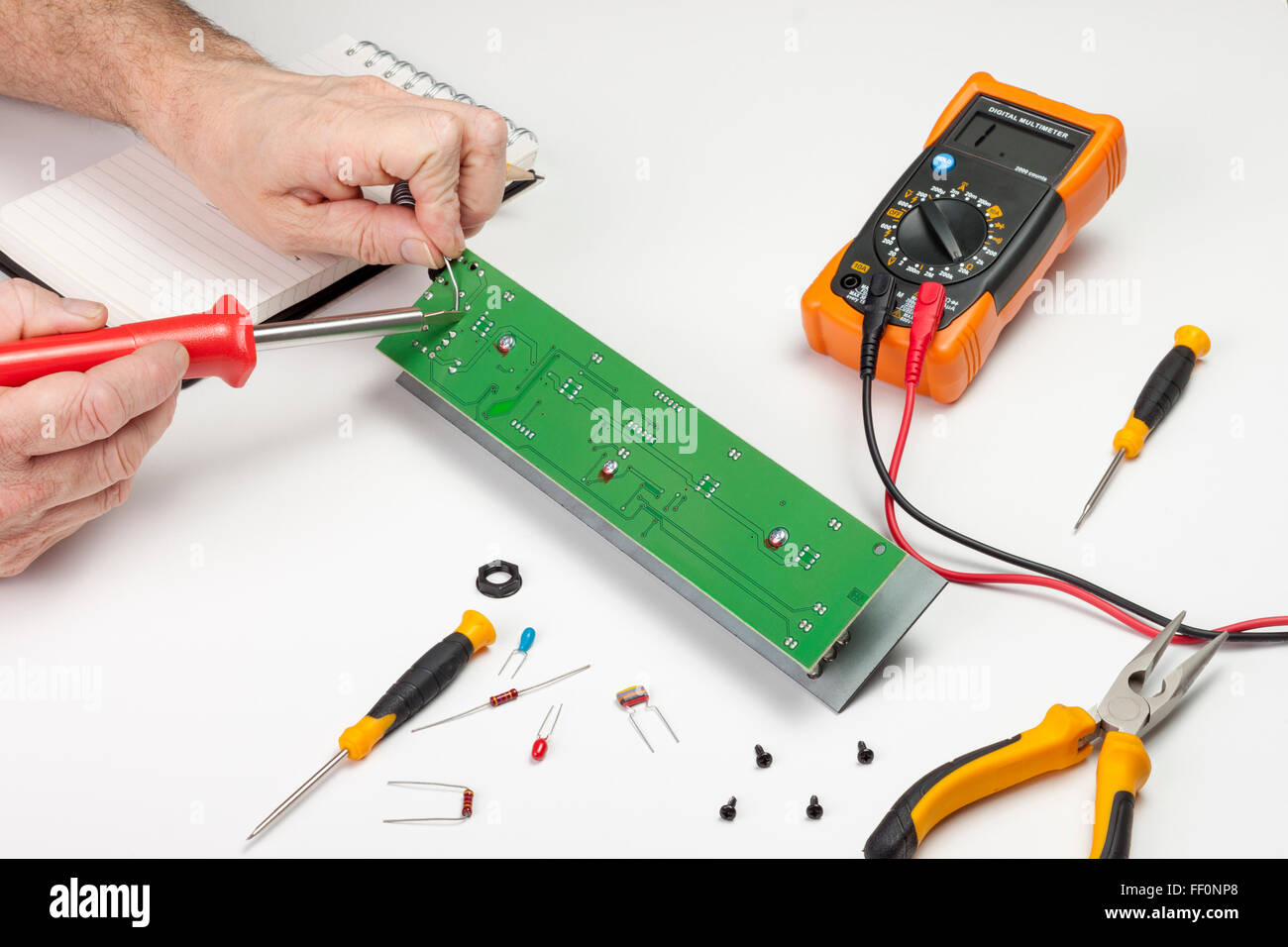 Electronics engineer at his workbench using a soldering iron Stock ...