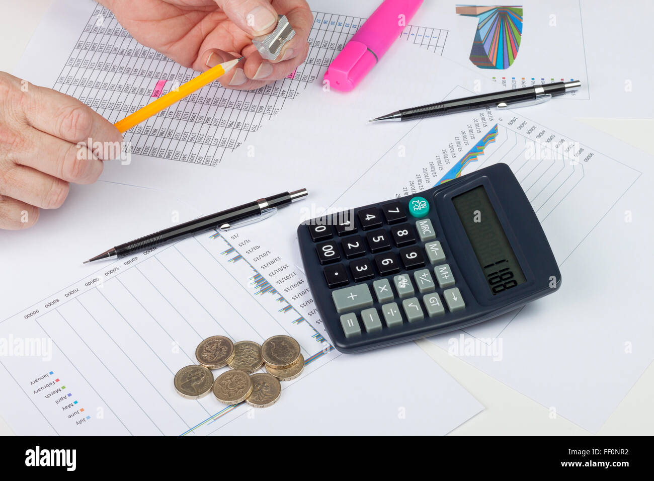 Hard working accountant sharpening his pencil at his desk while ...