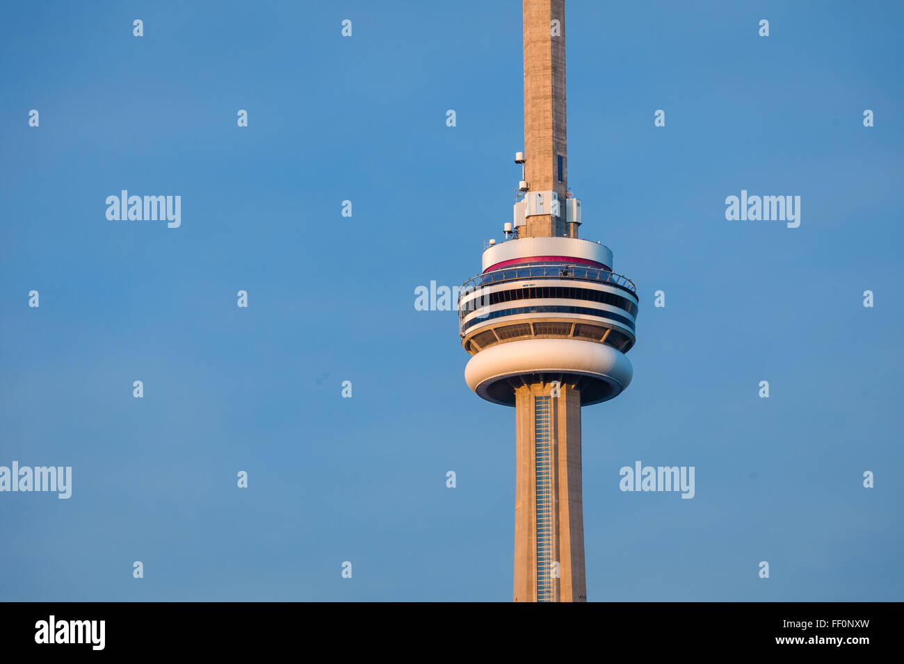 Very direct image of the CN Tower closeup against a plain blue sky ...
