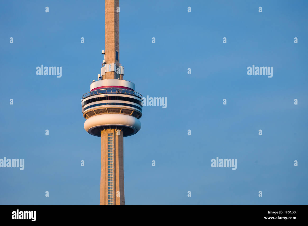 Very direct image of the CN Tower closeup against a plain blue sky ...