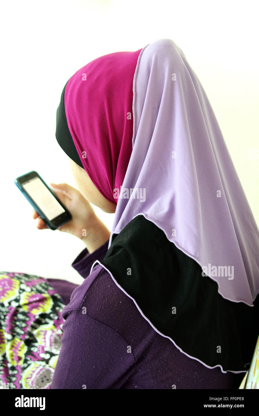 Muslim female using mobile phone Stock Photo - Alamy