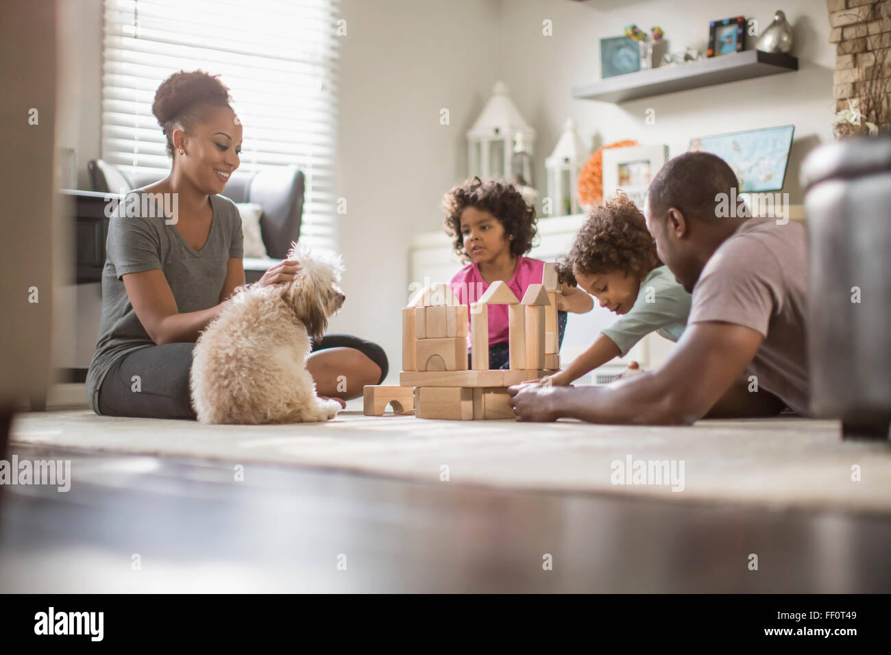 Family playing with building blocks in living room Stock Photo - Alamy