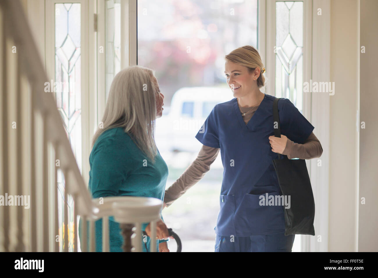 Nurse talking to patient in front door Stock Photo - Alamy
