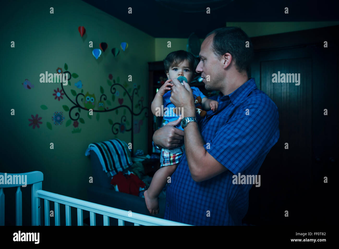 Father giving baby son pacifier in nursery Stock Photo - Alamy