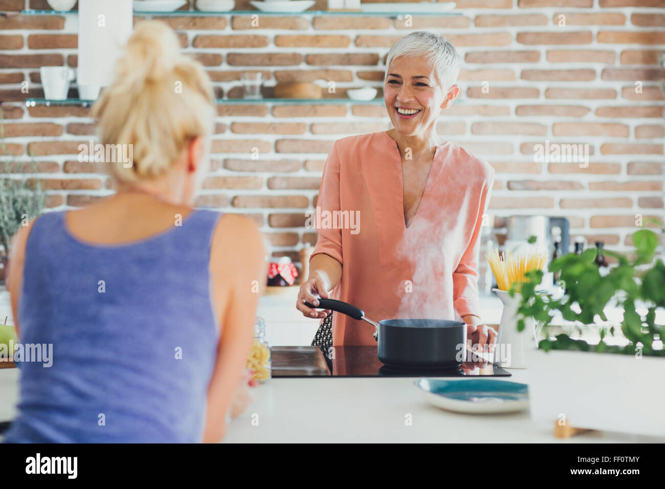 Women talking in kitchen Stock Photo - Alamy