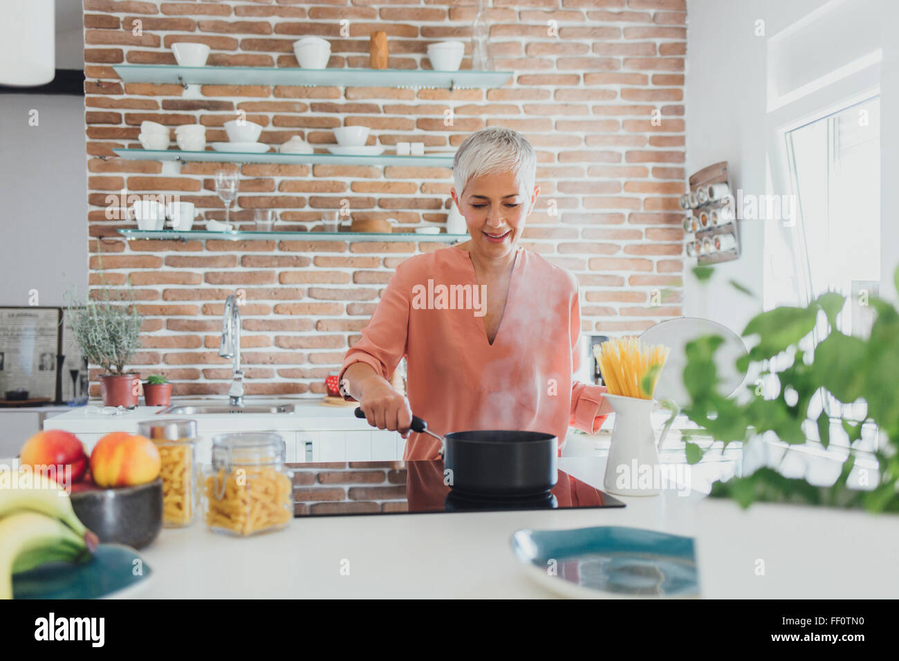 Older Caucasian woman cooking spaghetti in kitchen Stock Photo - Alamy