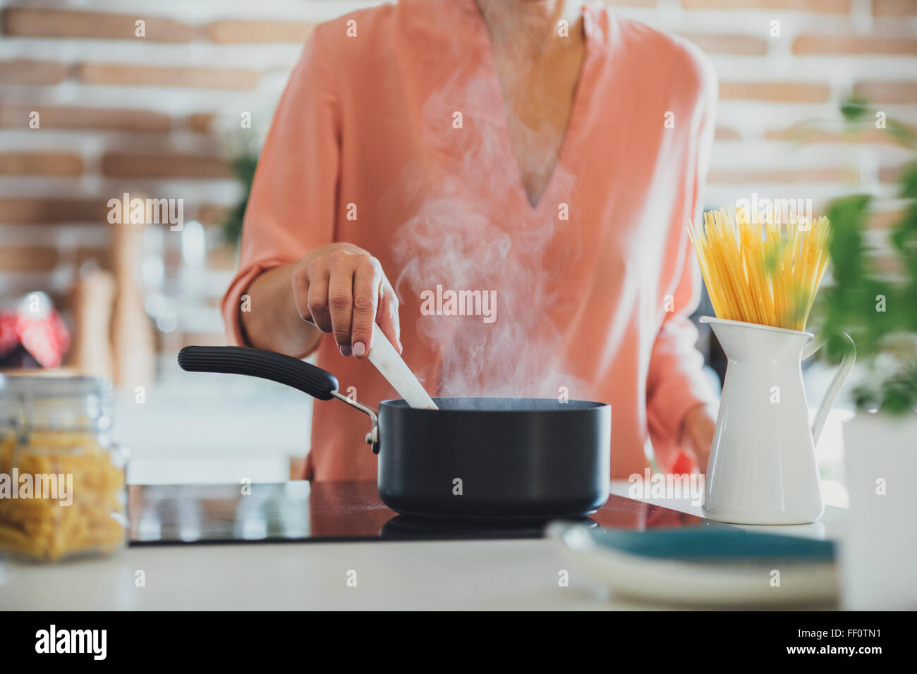 Older Caucasian woman cooking in kitchen Stock Photo - Alamy