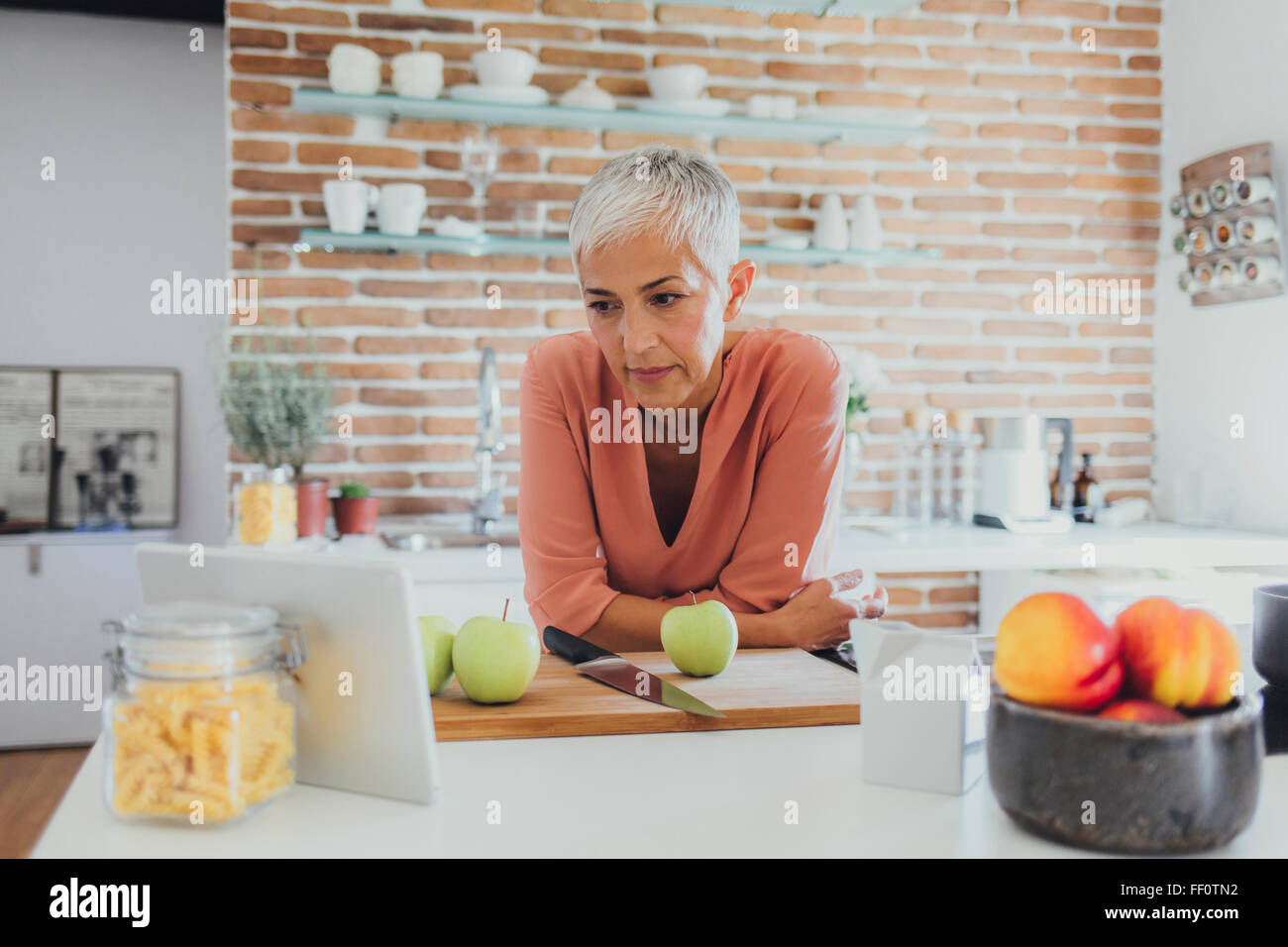 Older Caucasian woman cooking in kitchen Stock Photo - Alamy