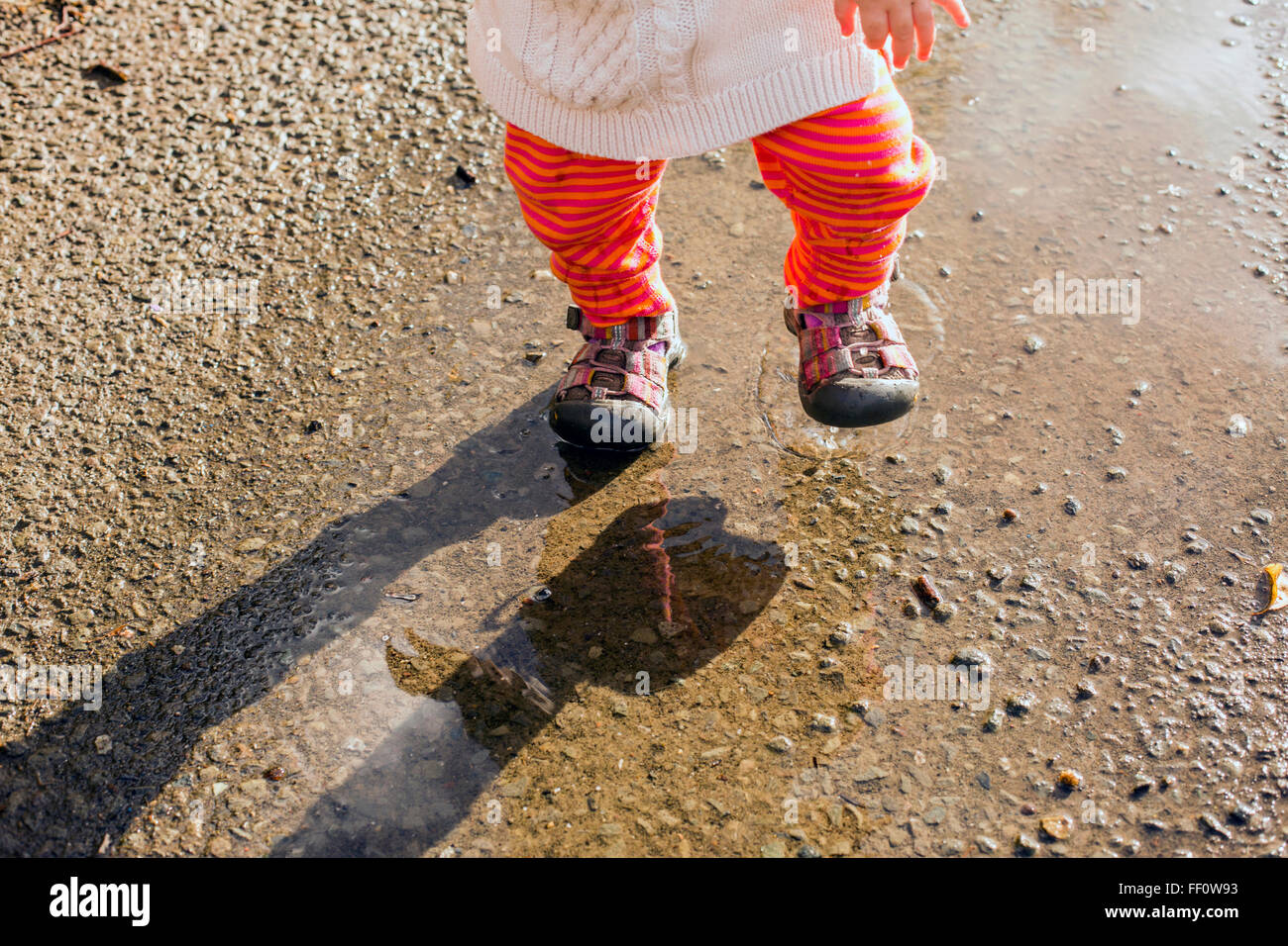 Caucasian baby girl walking in puddle Stock Photo - Alamy