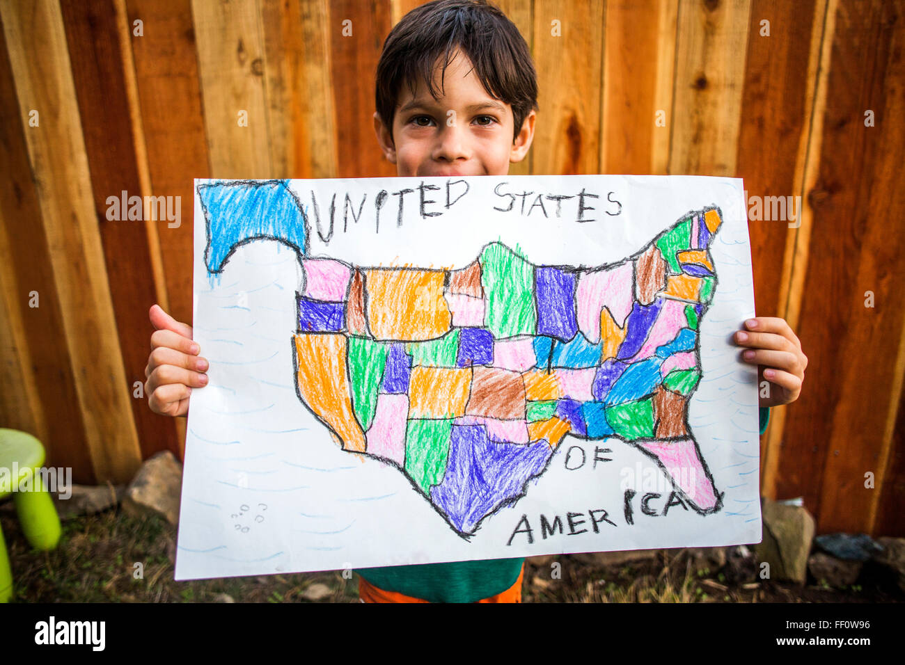 Mixed race boy holding United States map Stock Photo - Alamy