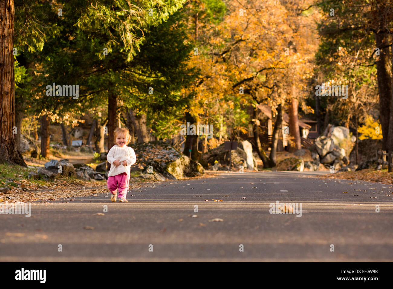 Caucasian baby girl walking on road Stock Photo - Alamy